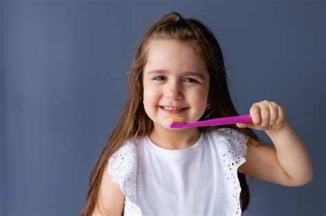 Una niña cepillándose los dientes con un cepillo de dientes Foto Premium