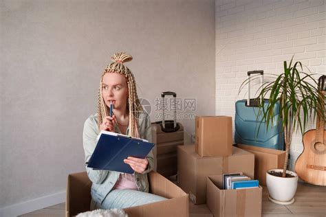 穿着散装坐在盒子里的漂亮女人把她的东西包装在箱子高清图片下载 正版图片504173197 摄图网