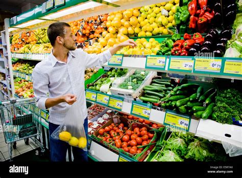 Man Shopping In Fruits And Vegetables Section In Supermarket Stock