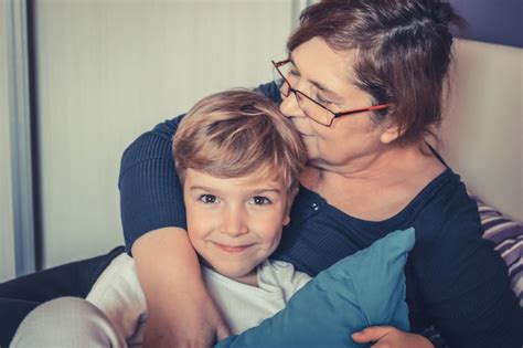 Premium Photo Grandmother Kissing Grandson On Bed