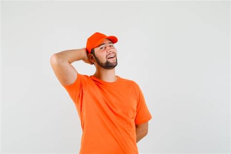 Free Photo Delivery Man In Orange T Shirt Cap Posing With Hand