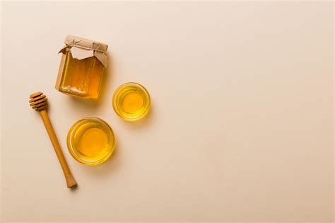 Premium Photo Glass Jar Of Honey With Wooden Drizzler On Colored Background Honey Pot And