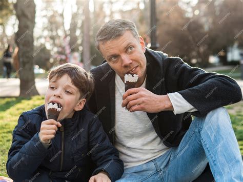 Padre E Hijo Comiendo Helado En El Parque Foto Gratis