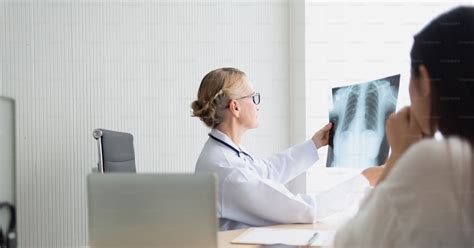선임 여성 의사가 의료실에서 환자의 X선 필름을 검사하고 보고 있다 사진 Unsplash의 의사 환자 이미지