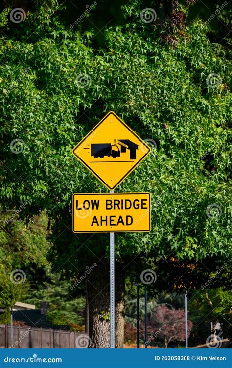Yellow Road Sign Low Bridge Ahead With A Truck And Bridge Symbol