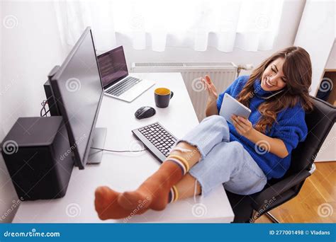 Female Software Developer Having Phone Conversation While Working In