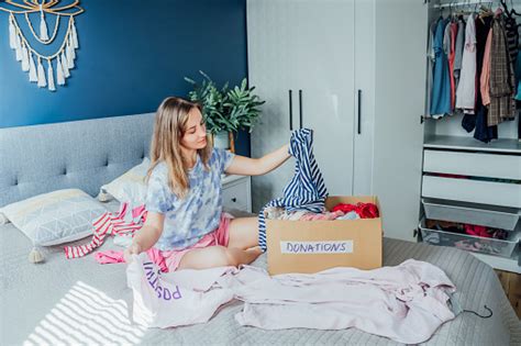 자선 상점에 기부하기 위해 옷장에서 옷을 선택하는 여성 정리 옷 정리 및 청소 재사용 중고 개념 의식있는 소비자 지속 가능한 라이프 스타일 여성에 대한 스톡 사진 및 기타