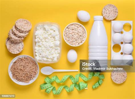 다이어트 건강 식품입니다 요구르트 빵 메 밀 국수 오트밀 코 티 지 치즈 계란 트레이 노란색 배경에 눈금자 라운드 바 삭의 병