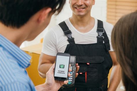 Premium Photo After Completing The Move Couple Pays With Smartphone