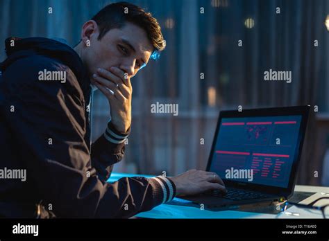 man looking in the camera hacker attacks and stealing access databases