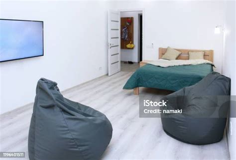 더블 침대 스칸디나비아 디자인 침실 인테리어 미니멀리즘과 Tv와 두 프레임없는 회색 안락 의자 가구에 대한 스톡 사진 및 기타