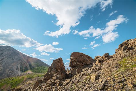 흐린 하늘 아래 햇빛에 바위 언덕에 돌 이상값과 경치 풍경 변화하는 날씨에 푸른 하늘의 구름 아래 돌 산에 햇빛이 비추는 날카로운 바위가있는 다채로운 풍경 0명에 대한 스톡