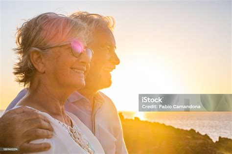 함께 여름을 즐기고 일몰바다나 바다를 바라보며 해변에서 즐거운 시간을 보내는 두 명의 귀여운 노인들 좋은 라이프스타일을 가진