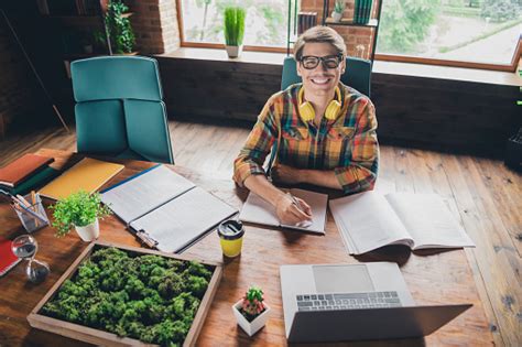 잘 생긴 젊은이가 입고 체크 무늬 셔츠를 입고 테이블 직장 쓰기 숙제 실내 사무실 로프트 인테리어 20 24세에 대한 스톡 사진 및 기타 이미지 Istock