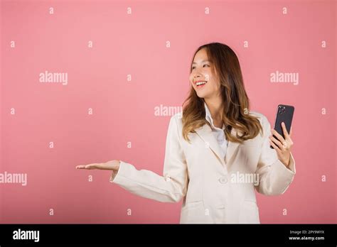 Woman Excited Holding Mobile Phone Blank Screen Presenting Product With Palm Of Hand At Empty