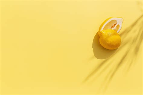 黄色の背景にヤシの葉から影を持つレモンの2つの半分のカット かんきつ類のストックフォトや画像を多数ご用意 かんきつ類 ひらめき