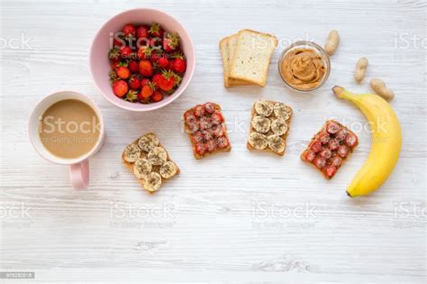 라 떼와 함께 건강 한 아침 식사입니다 채식주의와 과일 씨앗 땅콩 버터 토스트 흰색 나무 배경 평면도입니다 위에서 플랫이 하다