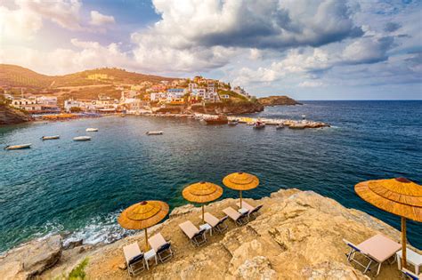 일출 Rethymno 크레타 그리스발리에서 선박 보트 해변과 등대와 항구의 파노라마 레티노 크레타 그리스 근처 발리 마을에서