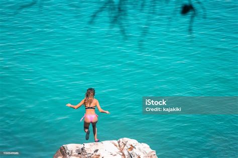 夏の休暇で崖から飛び降りて青い海に飛び込む若い女性 崖のストックフォトや画像を多数ご用意 崖 クリフダイビング ジャンプする