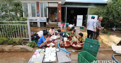 진흙 묻은 그릇 씻는 이길리 마을 주민들