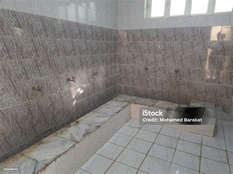 흰색과 회색 세라믹으로 덮여 있고 흰색 창문이 있는 모스크 욕실에서 기도하기 전에 목욕재계를 할 수 있는 장소에 수도꼭지가 있습니다 0명에 대한 스톡 사진 및 기타 이미지