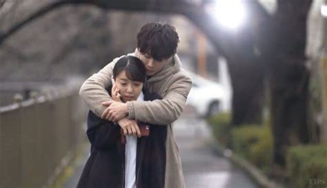 Two People Hugging Each Other On The Street