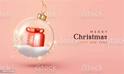 메리 크리스마스와 새해 복 많이 받으세요 크리스마스 장식품은 눈 위에 선물 상자 측면이 있는 유리 투명 공입니다 골드 리본에 매달려있는 크리스마스 공입니다 휴일 크리스마스