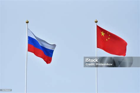 러시아와 중국 국기 우정의 상징 중국과 러시아는 흰색 흐린 푸른 하늘에 대 한 바람에 흔들며 국기를 함께 외교 개념 국제 관계