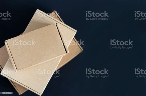 서로 다른 두께와 크기의 세 개의 골판지 상자가 서로 위에 검은 색 배경에 서 있습니다 3가지 개체에 대한 스톡 사진 및 기타