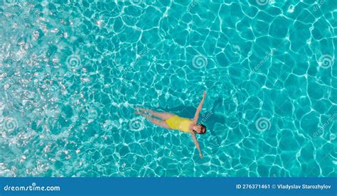 top down view of a woman in yellow swimsuit lying on her back in the