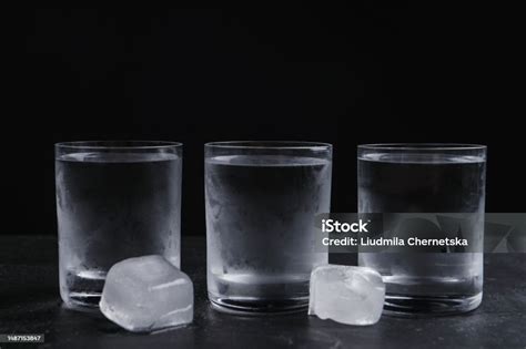黒い背景にショットグラスのウォッカとテーブルの上に氷 お祝いのストックフォトや画像を多数ご用意 お祝い アルコール飲料 ウォッカ