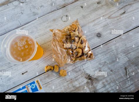 Une pinte de bière dans un récipient en plastique et un sac ouvert de