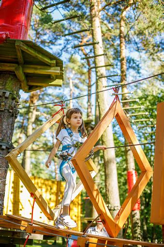 집중한 표정을 짓는 어린 소녀가 어드벤처 파크에서 도전적인 하이 로프 코스를 탐색합니다 6 7 살에 대한 스톡 사진 및 기타 이미지 6 7 살 건강한 생활방식 결심