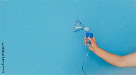 Medical Inhaler In Hand On A Blue Background Asthma Disease Treatment