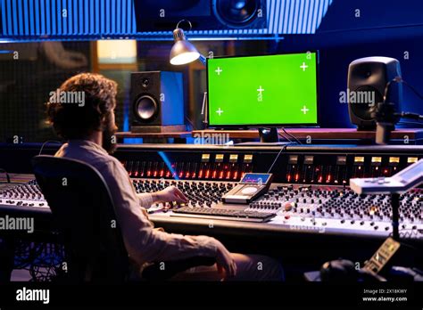 Sound Designer Working On Mixing And Mastering Tracks With Mockup Display Using Control Panel