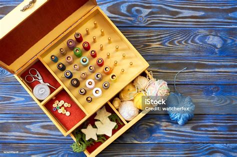 파란색 나무 배경에 실 단추 가위 및 장식으로 바느질과 바느질 패턴이 있는 노란색 상자를 엽니다 평면도 0명에 대한 스톡 사진 및 기타 이미지 Istock