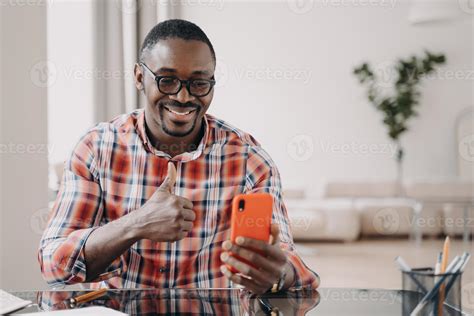 African American Man Shows Thumb Up Hand Gesture Holding Phone Smiling