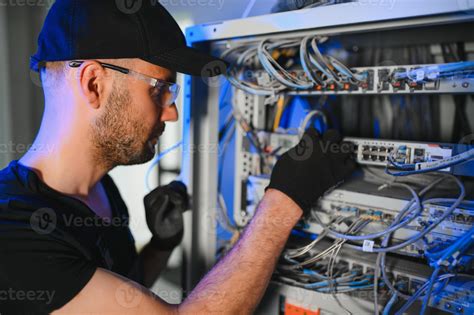 A Technician Works With Server Equipment In A Data Center A Man