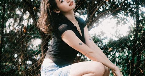 스타일리시한 옷차림으로 야외에서 포즈를 취하는 젊은 여성 · 무료 스톡 사진