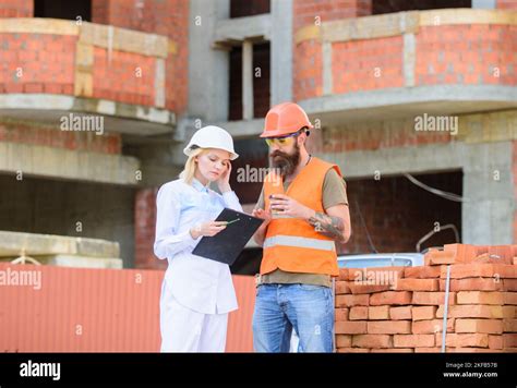Discussing Plan Woman Engineer And Builder Communicate At Construction Site Construction Team