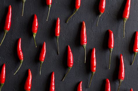 검은 색 테이블에 검은 어두운 배경에 빨간 뜨거운 칠리 고추 붉은 고추 고추의 많은 텍스트의 공간을 복사합니다 플랫 레이 상단