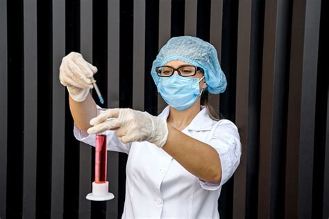 시험관과 보호 유니폼을 가진 여성 화학자는 두 가지 물질을 가진 실험을 합니다 Stem 주제에 대한 스톡 사진 및 기타 이미지