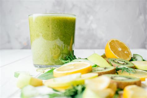 녹색과 노란색 과일과 허브가 흰색 테이블에 조각으로 자른 녹색 스무디의 부분적으로 흐린 유리 0명에 대한 스톡 사진 및 기타 이미지 Istock