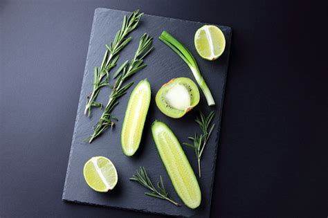 녹색 과일 그리고 야채 어두운 슬레이트 보드에 자연 그린 제품의 개념입니다 아보카도 키 위 라임 및 어두운 배경에 애플 로즈마리 딜과 돌 보드에 향신료 건강한 생활방식에