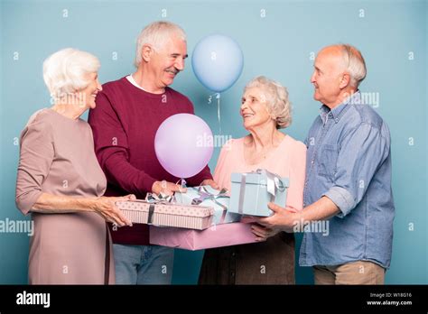 Cheerful Company Of Friendly Pensioners With Balloons And Tboxes