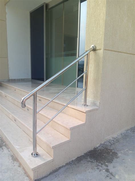 A Set Of Stairs Leading Up To A Building With Glass Doors And Railings