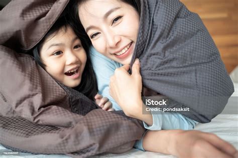 어머니와 그녀의 딸 아이 소녀 침실에서 재생 하 고 담요를 넣어 행복한 아시아 가족 2명에 대한 스톡 사진 및 기타 이미지