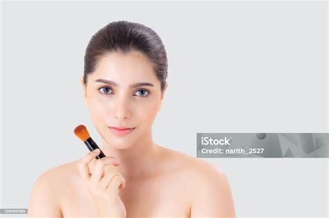흰색 배경 메이크업 및 화장품에 고립 된 얼굴에 뺨으로 블러셔를 바르는 아름다운 젊은 아시아 여성 얼굴에 브러시가있는 소녀