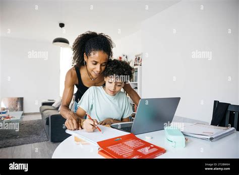 Cheerful Woman Helping Daughter Doing Homework Happy Mother Assisting