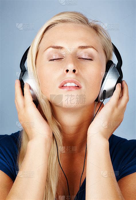 年轻漂亮的女孩戴着耳机听音乐